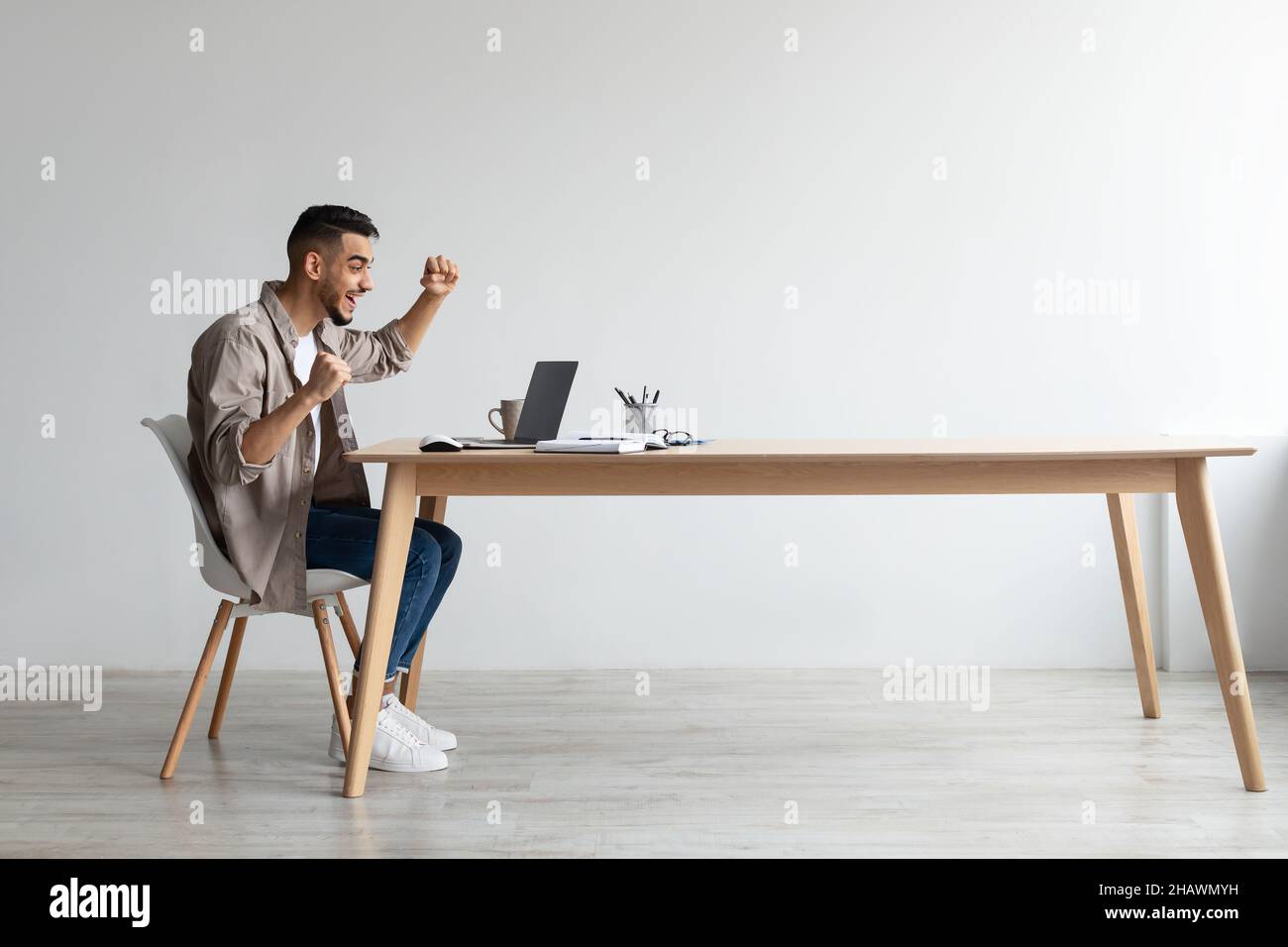Arab man using laptop celebrating success shaking fists screaming yes ...