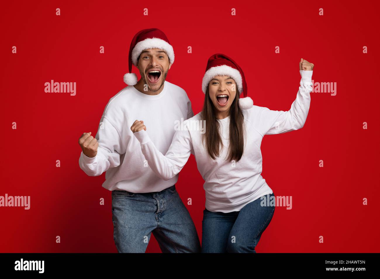 Christmas Joy. Cheerful Emotional Couple In Santa Hats Exclaiming With ...