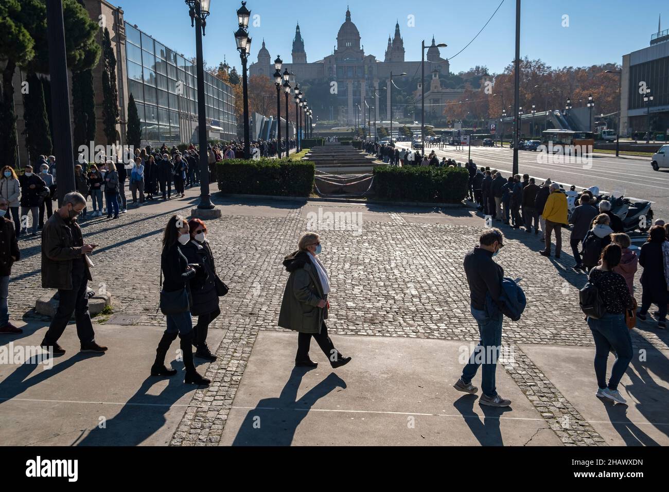 People are seen in a queue to receive the so-called "booster dose or ...