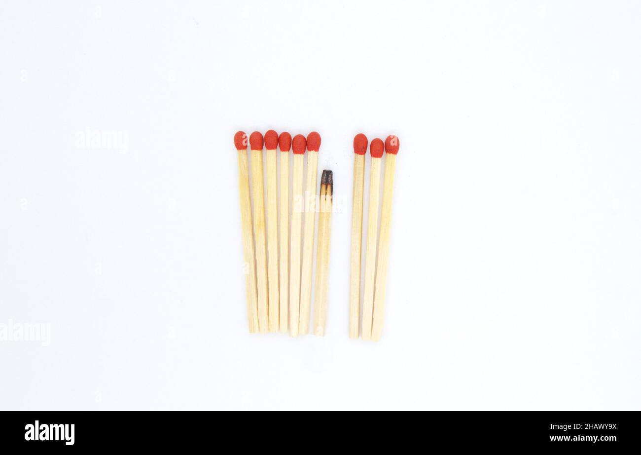 Burned matchstick with white negative space central surrouned by unused ...