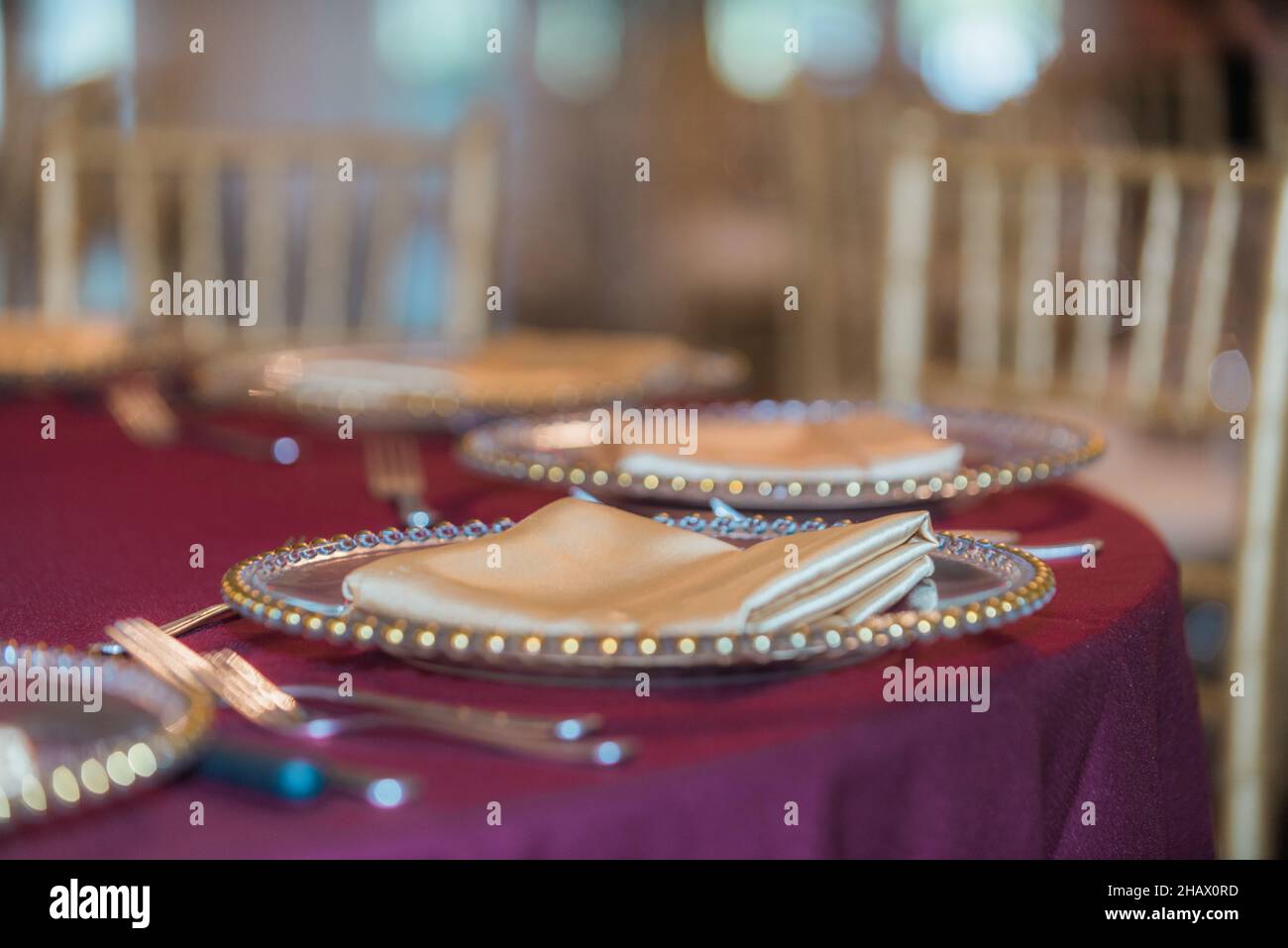 Red cloth table setting with gold plates and gold napkins Stock Photo ...