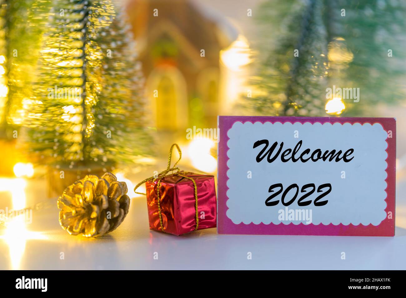 Welcome 2022 writing on greeting card with small house and lights ...