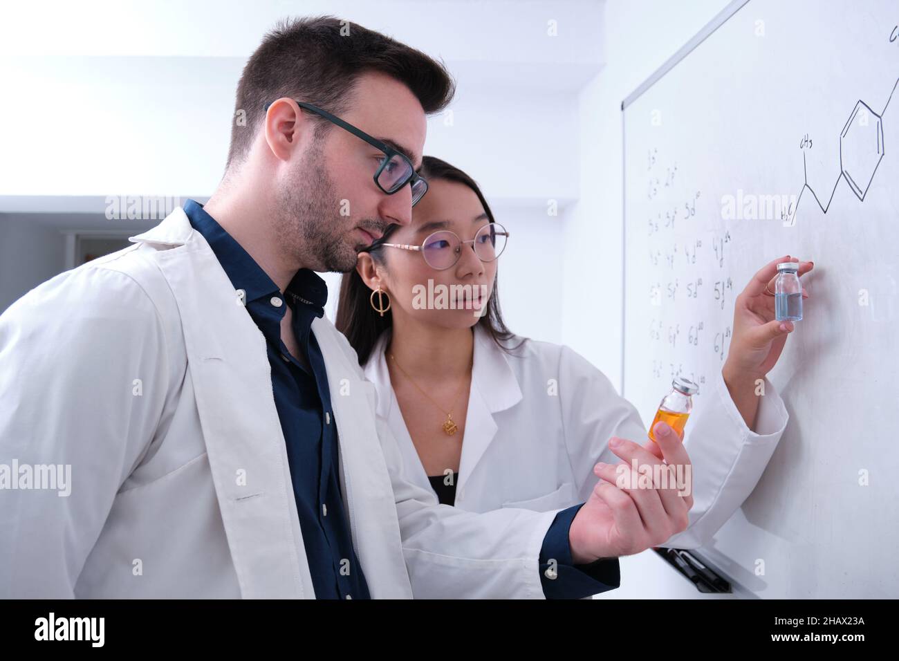 Two researchers comparing two medicine vials Stock Photo - Alamy