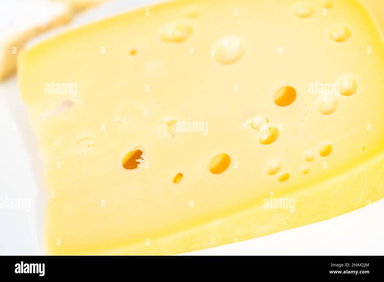 Large slice of semi soft part skim cheese on a white background Stock ...