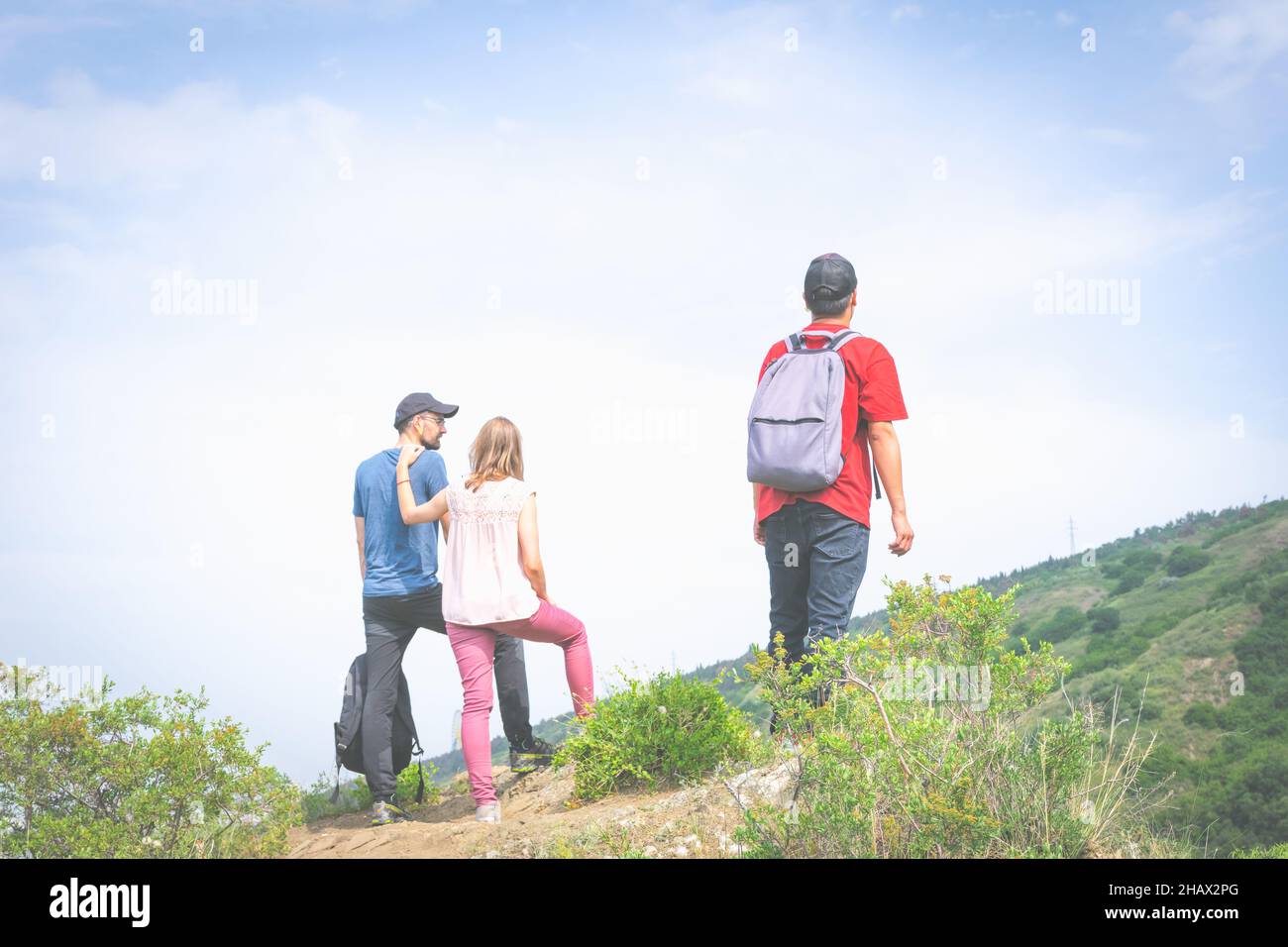 Three friends stands in nature and looks in different diections with ...