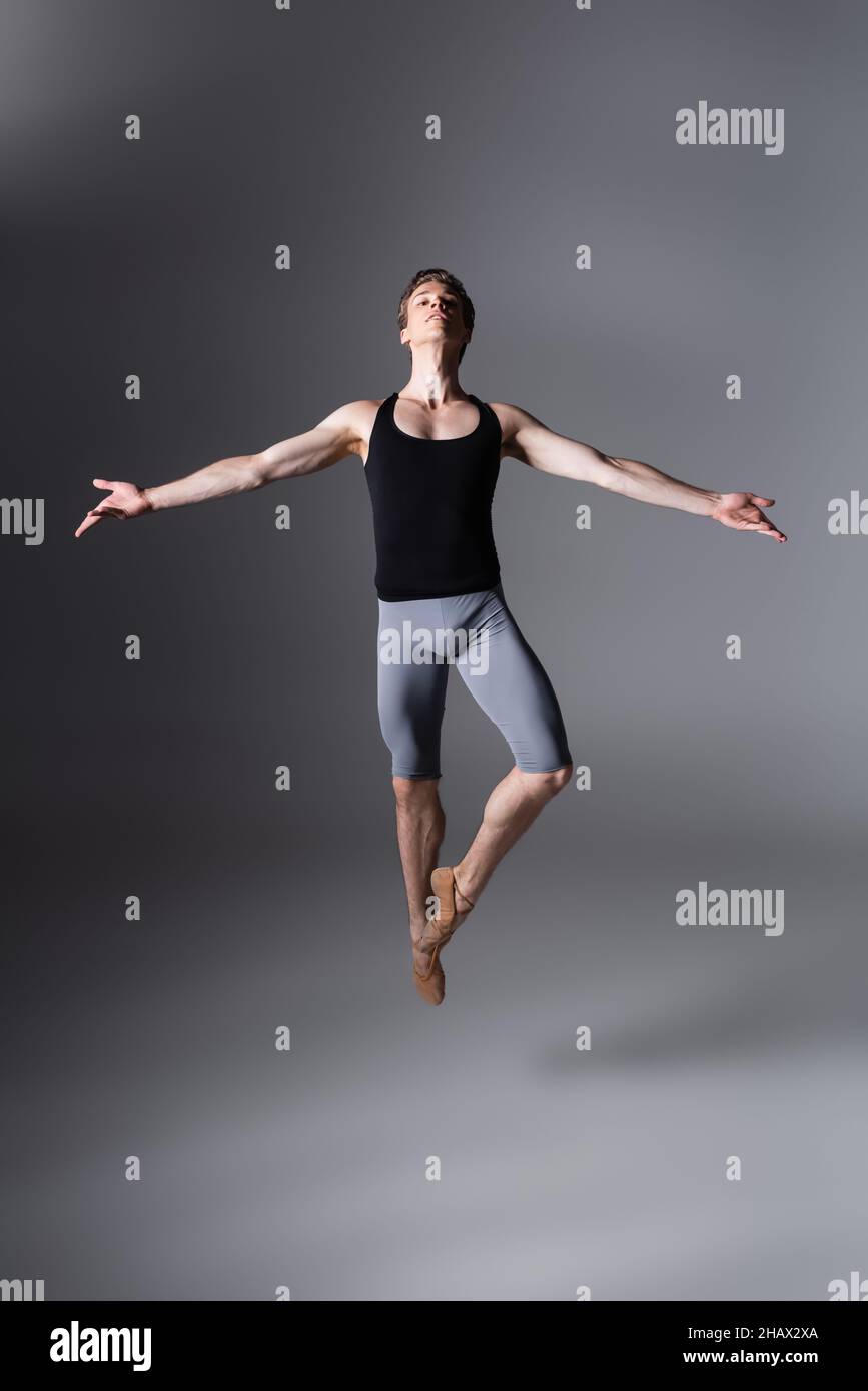 full length of elegant ballet dancer performing levitating with ...
