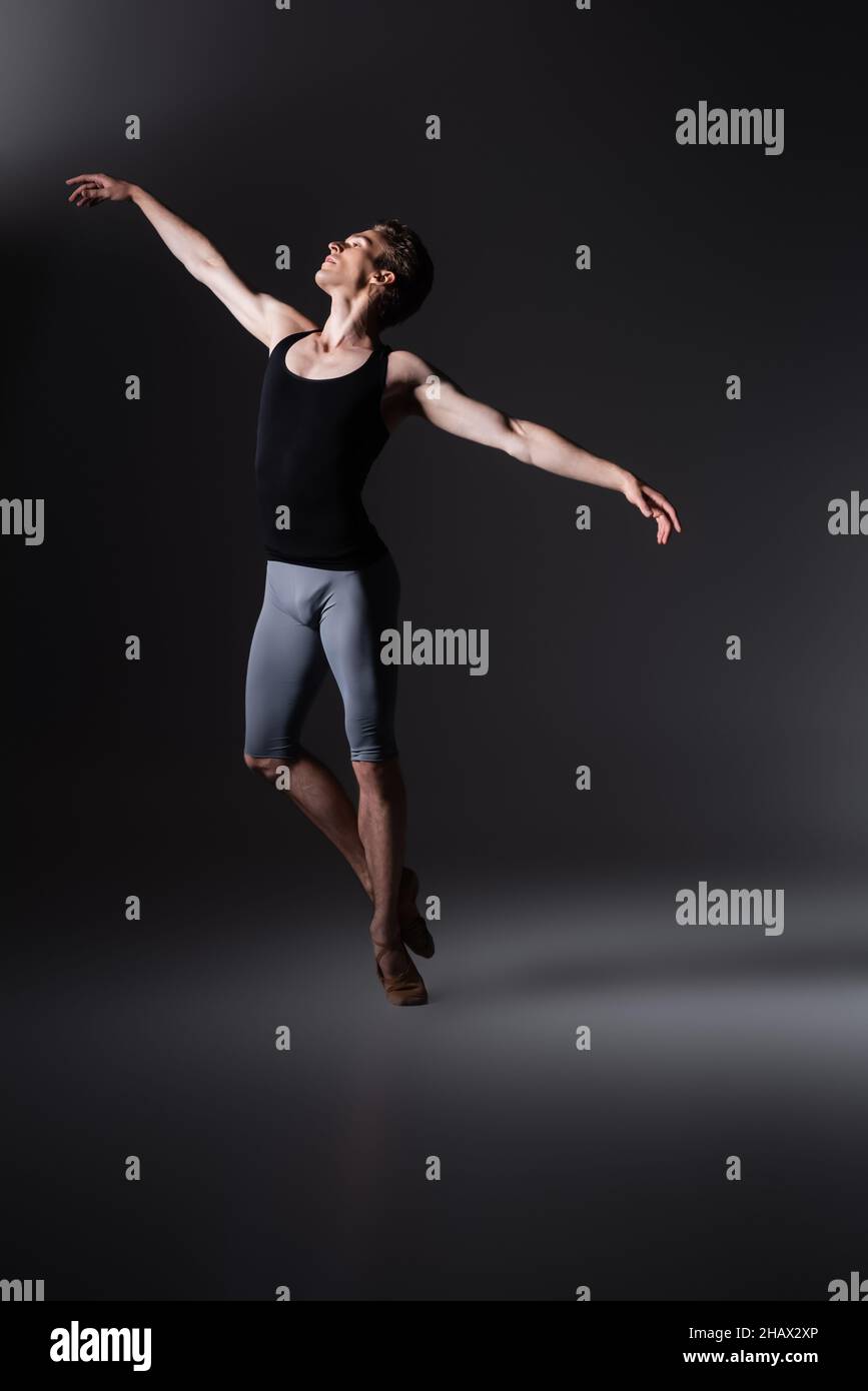 elegant man gesturing while performing ballet dance on black Stock ...