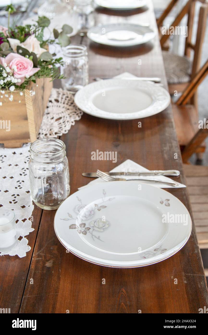 Vintage white plates at outdoor wood picnic table Stock Photo - Alamy