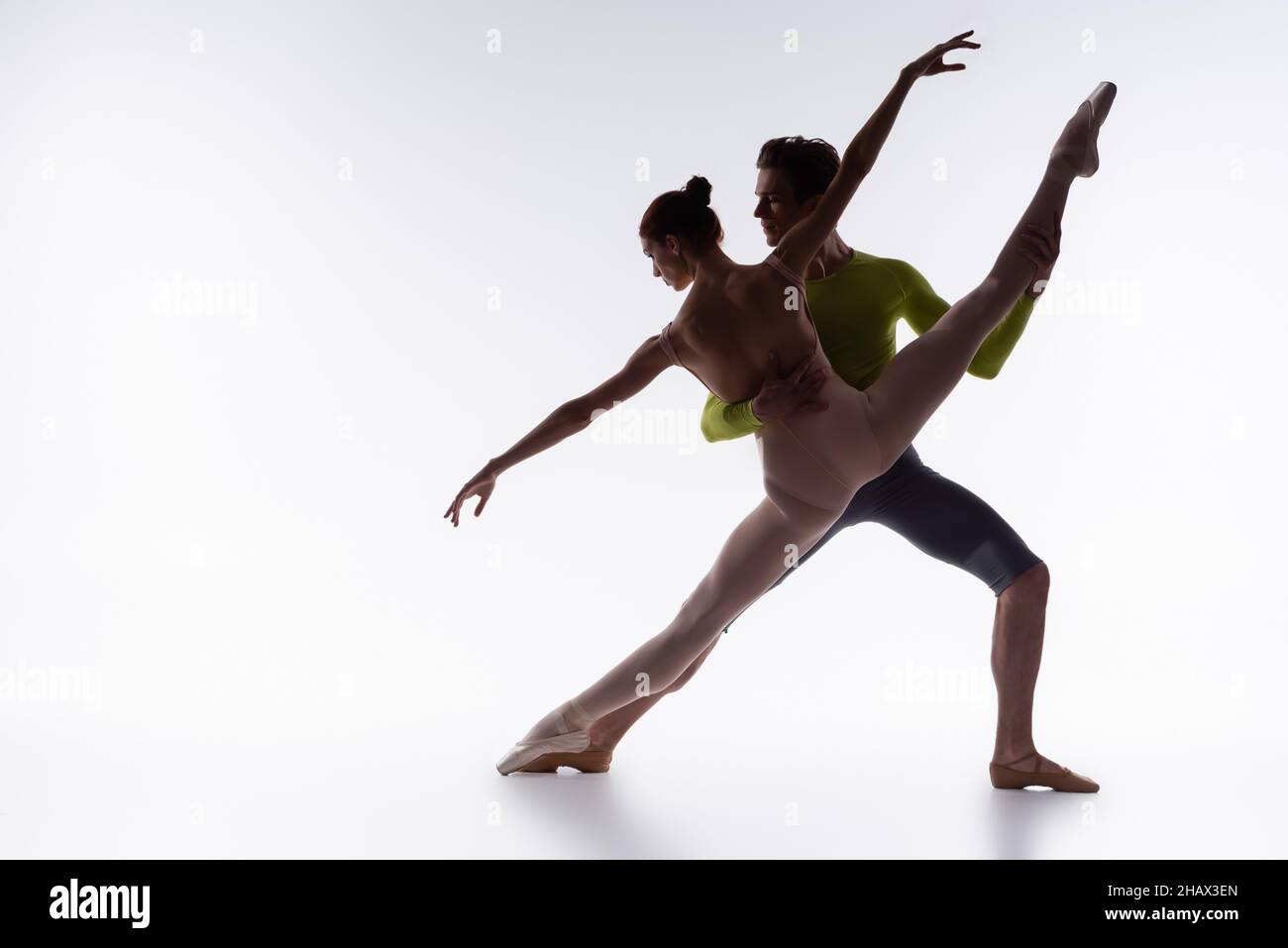 full length of flexible ballet dancers performing dance on white Stock ...