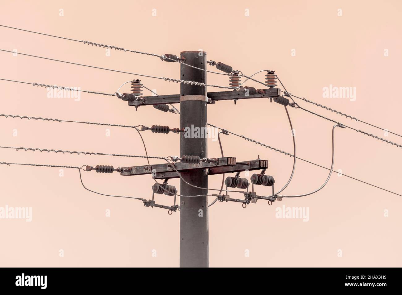 Photograph of a concrete telephone post and cables against an orange ...