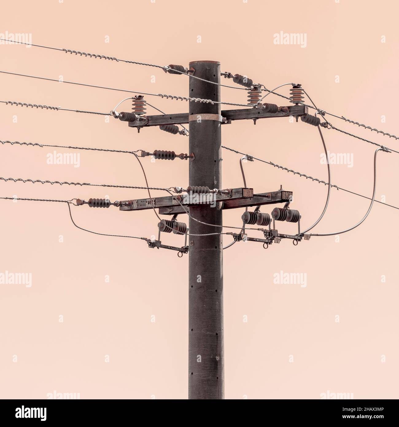 Photograph of a concrete telephone post and cables against an orange ...