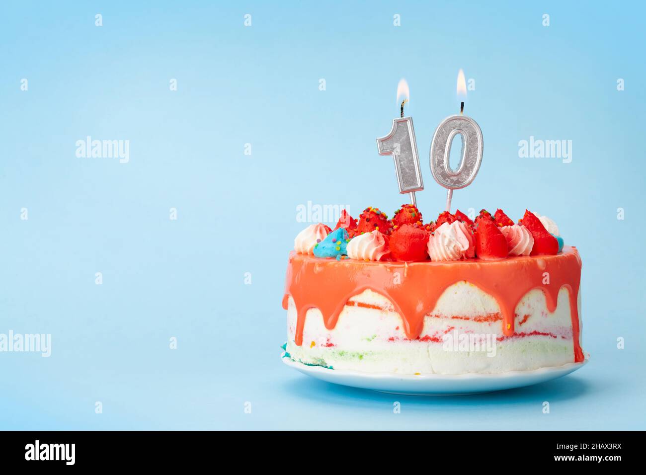 Birthday cake with number ten candle on a blue background with copy ...