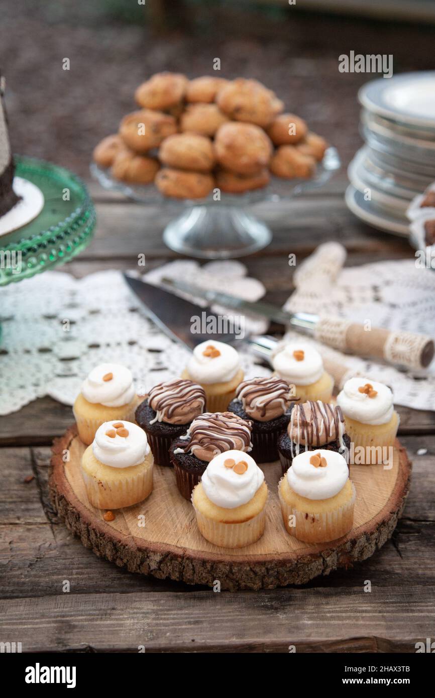 Variety of cupcakes on wood picnic table outdoors Stock Photo - Alamy