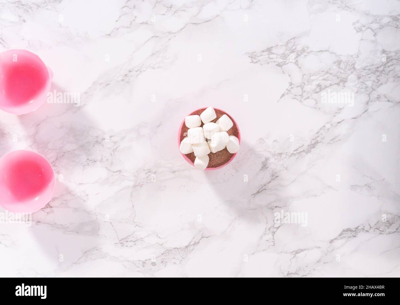 Filling in pink chocolate shells with hot chocolate mix and mini ...