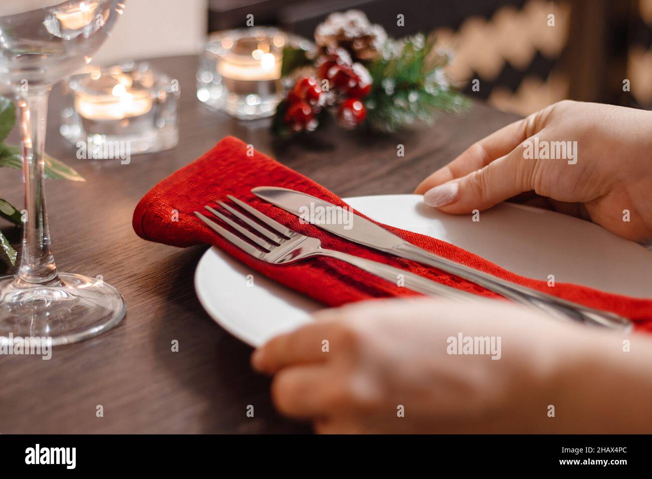 Woman serves Christmas table. Female hands hold plate with cutlery ...