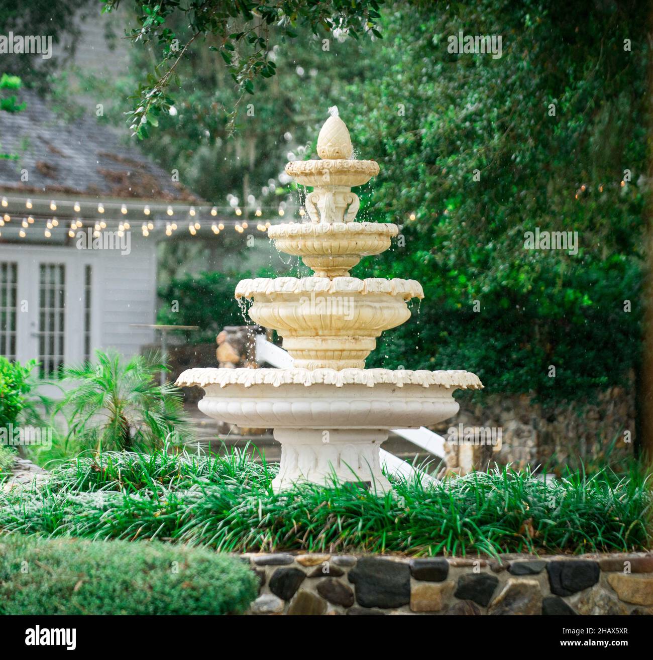 Amazing white stone water fountain in court yard Stock Photo - Alamy