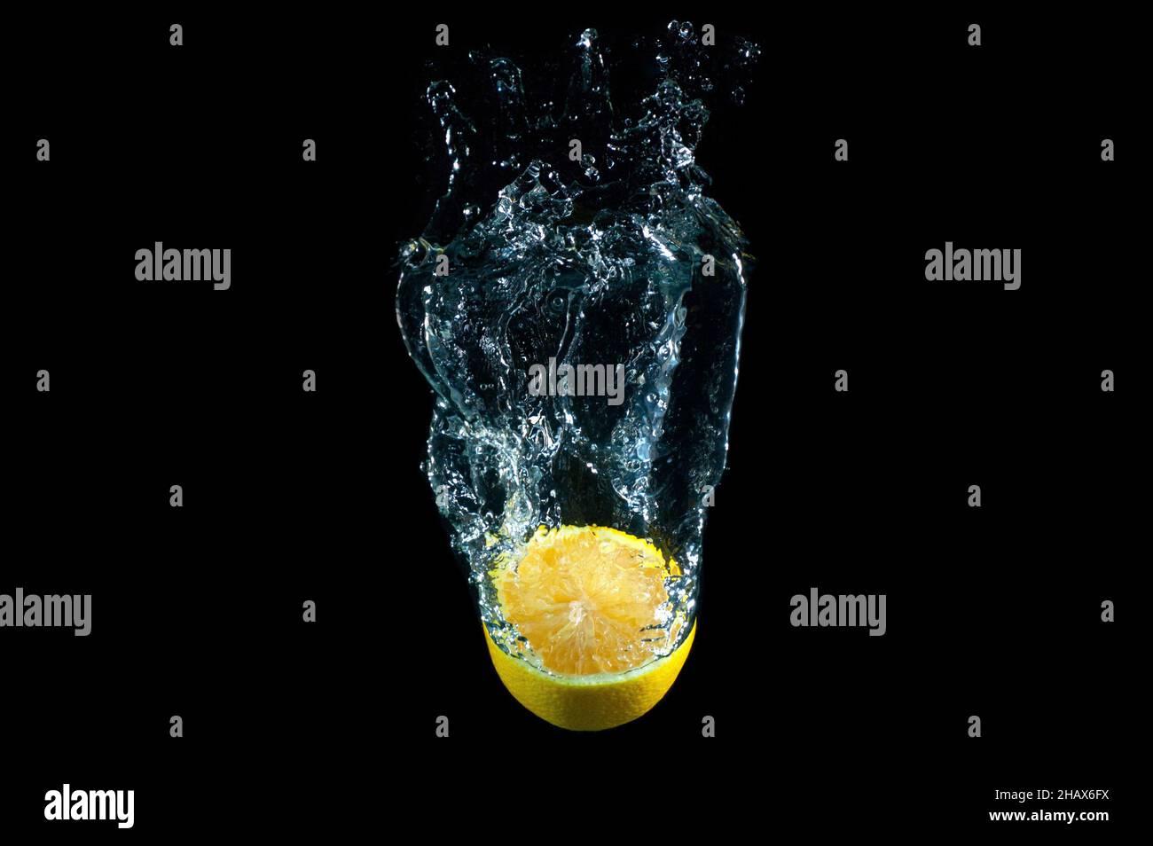 Halved lemon floating in water isolated on black background Stock Photo ...