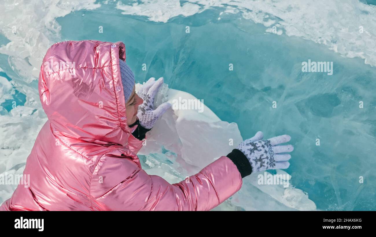 Girl walking on cracked ice of frozen lake Baikal. Woman traveler ...