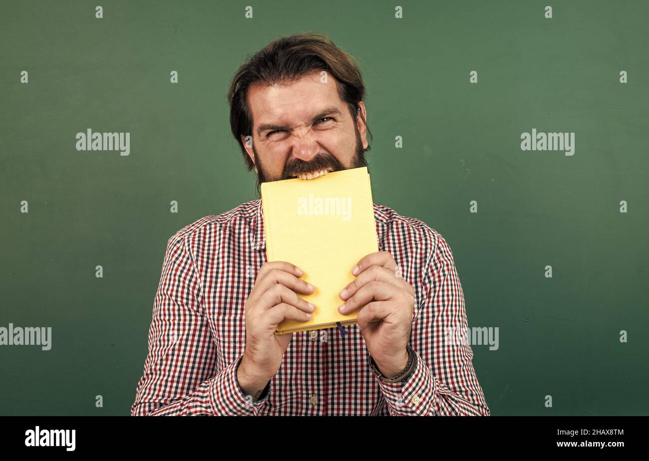 angry mature college man biting book, stress Stock Photo - Alamy