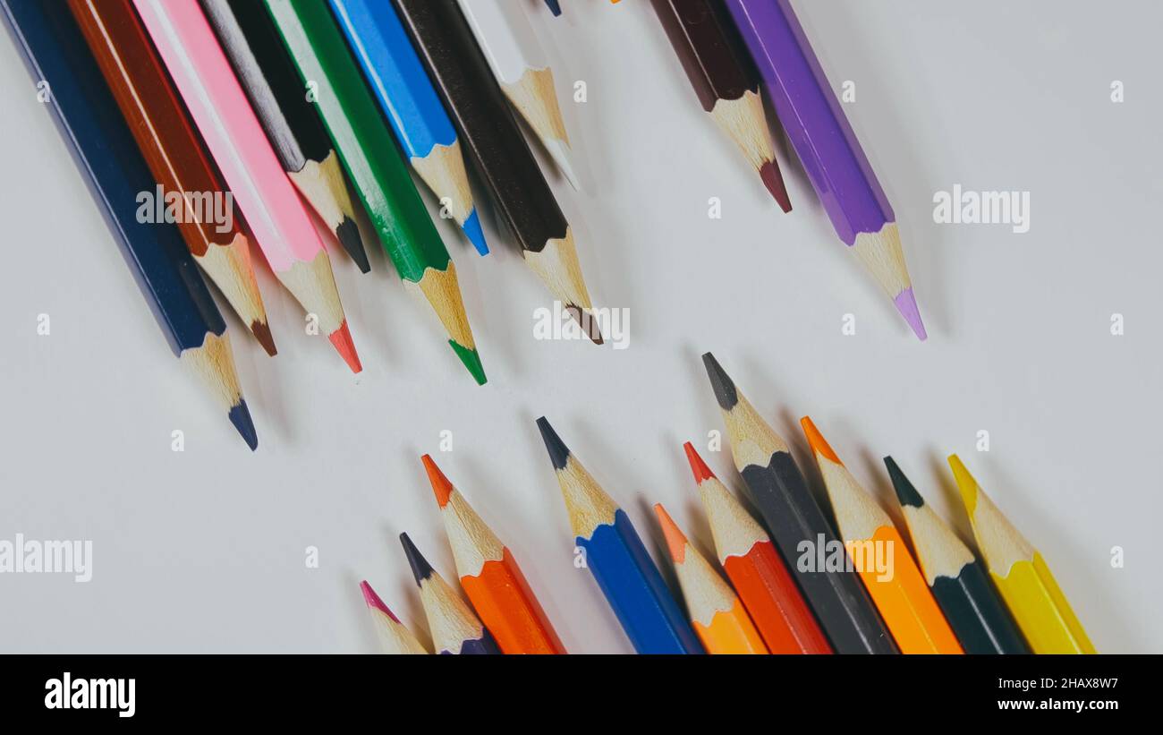 Many colored pencils are arranged around the edges of the image as a ...