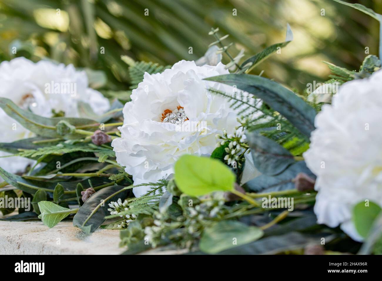 Diamond wedding ring inside of white rose ooutdoors Stock Photo - Alamy
