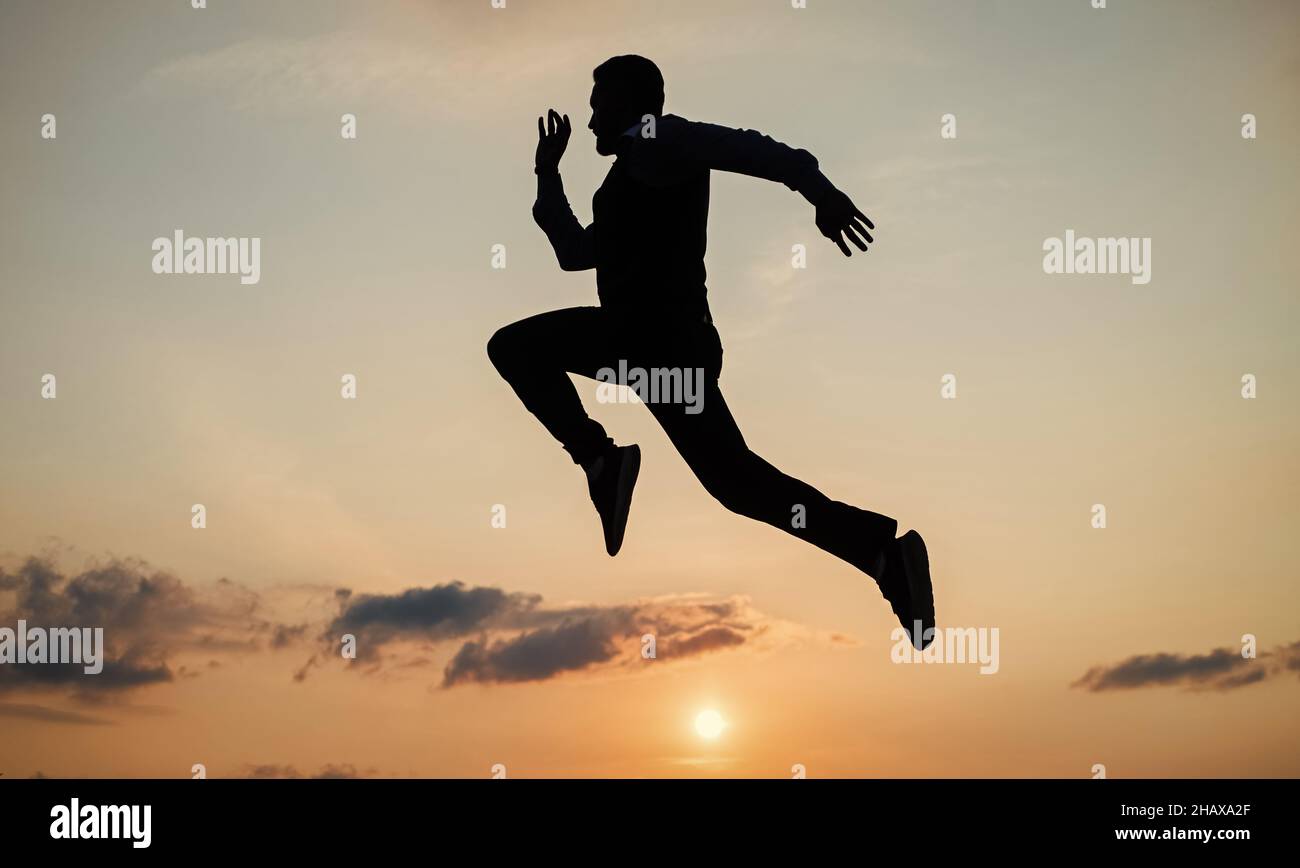 man runner silhouette running to future against sunset sky, success ...