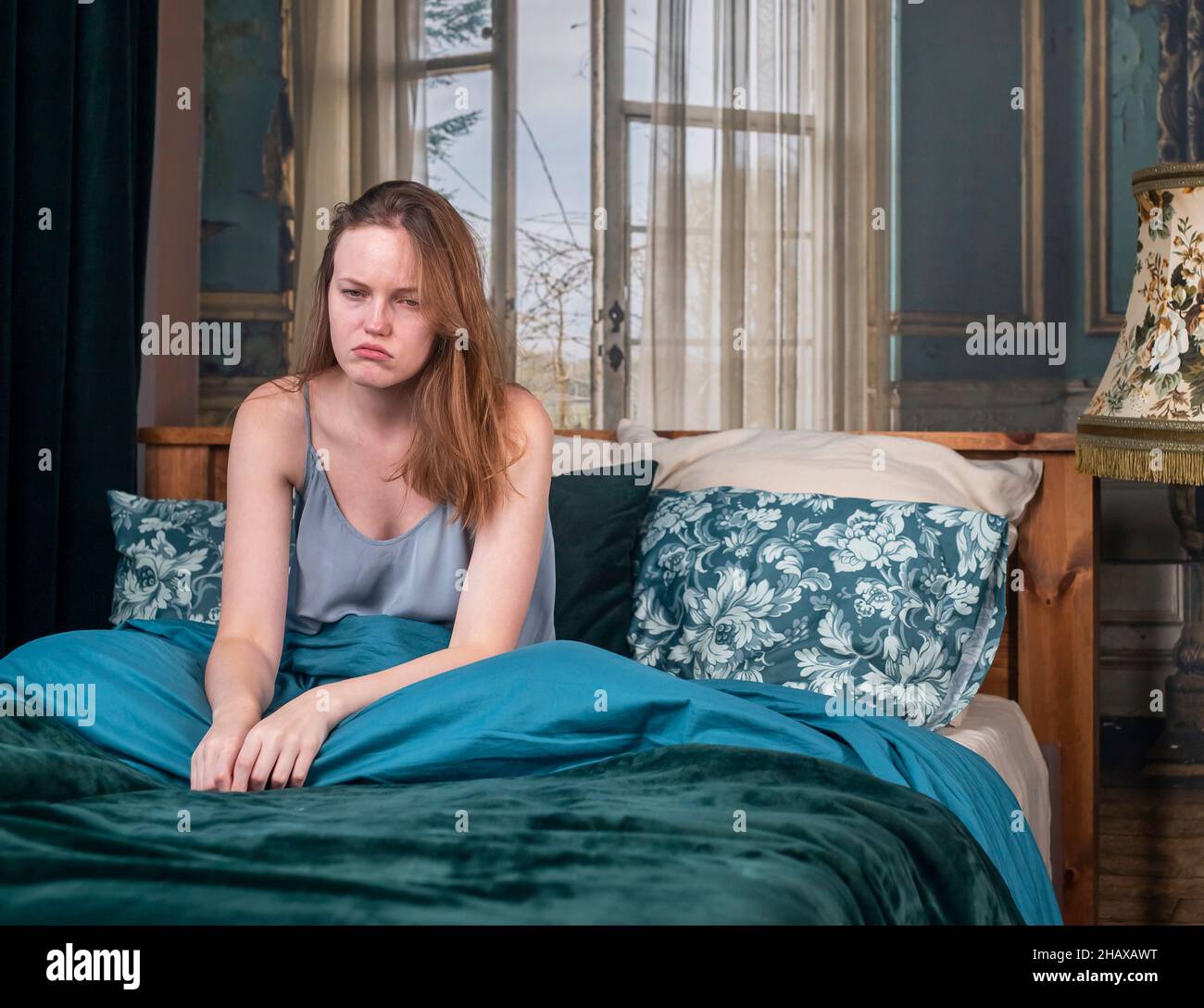 Hard wakeup concept. Tired gloomy young woman waking up early with ...