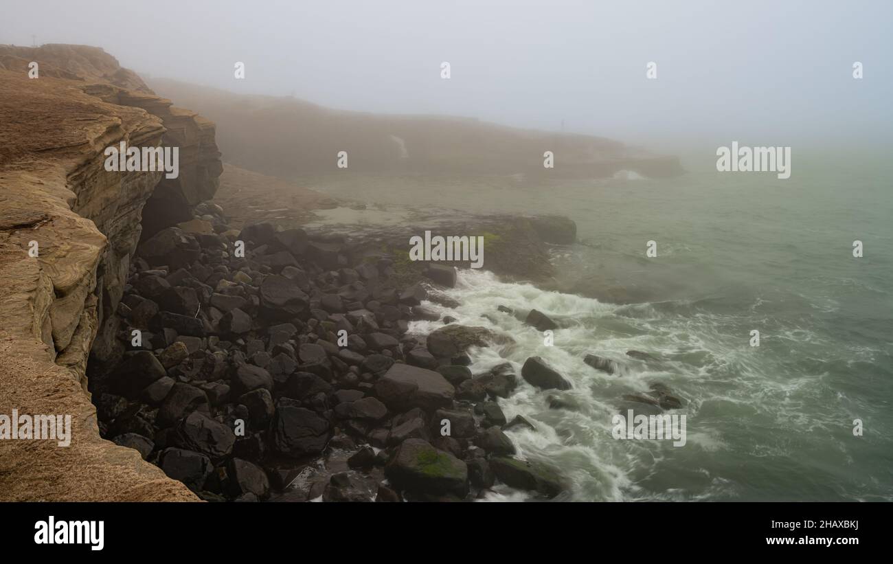 Person shrouded in mist, standing near the Sunset Cliffs arch, at the ...