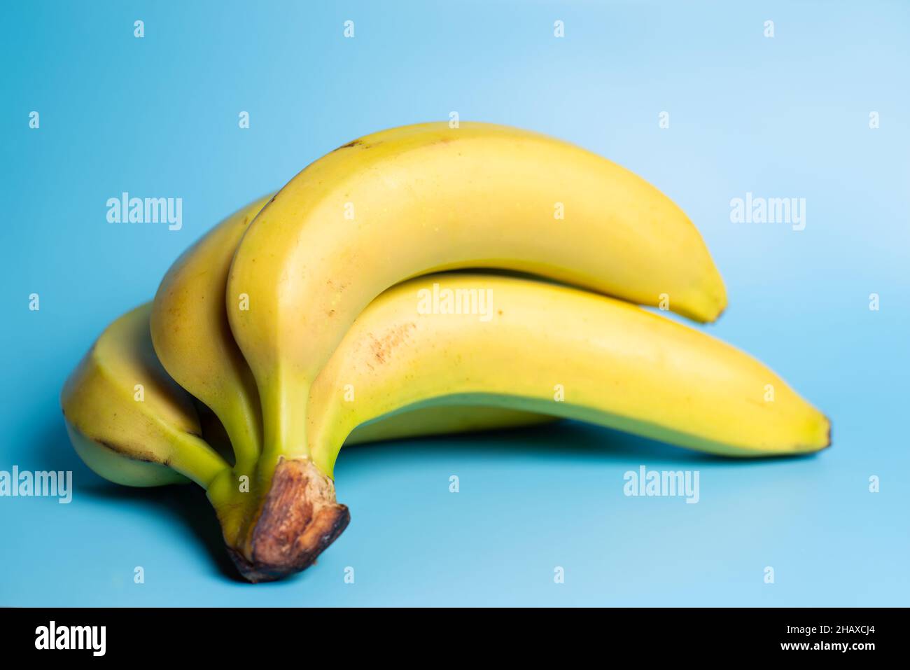 A bunch of bananas on a blue background Stock Photo - Alamy