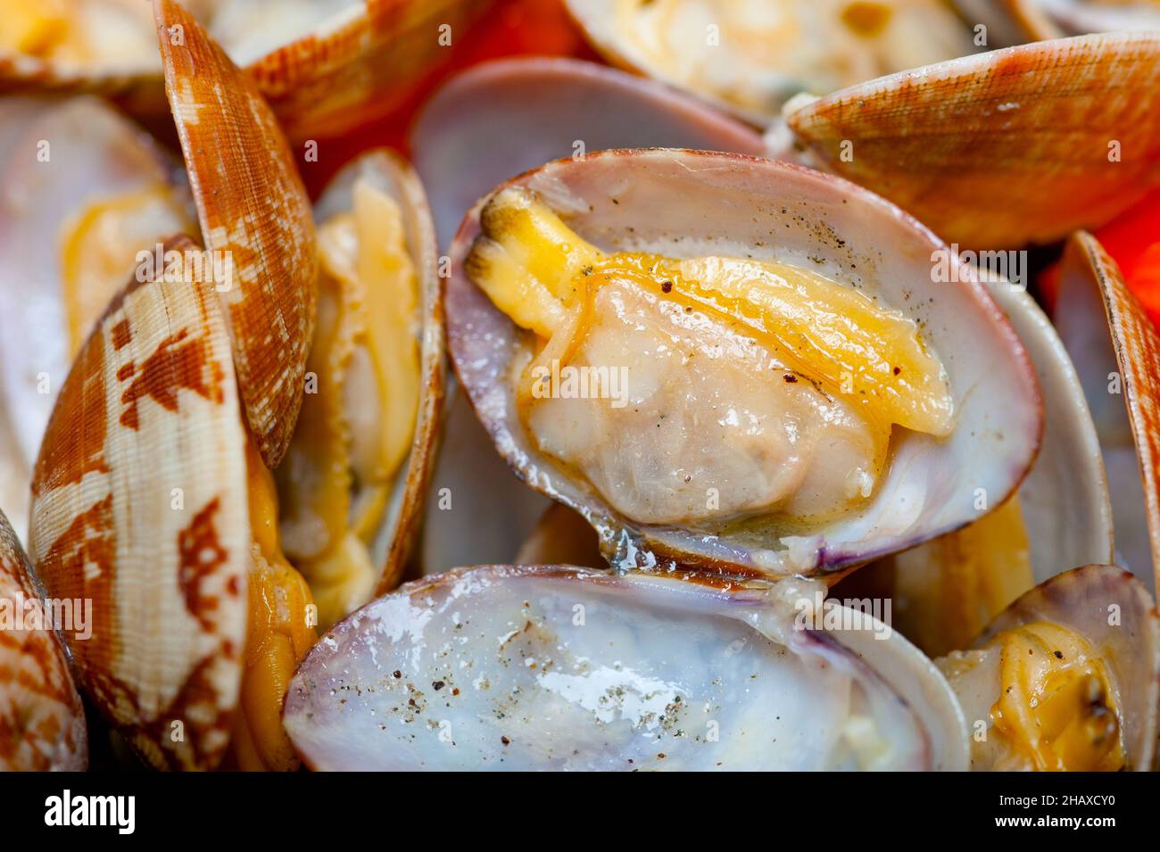 fresh clams stewed on an iron skillet over wite rustic wood table Stock ...