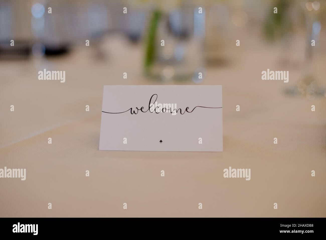 White "welcome" place card on celebration dinner table Stock Photo - Alamy