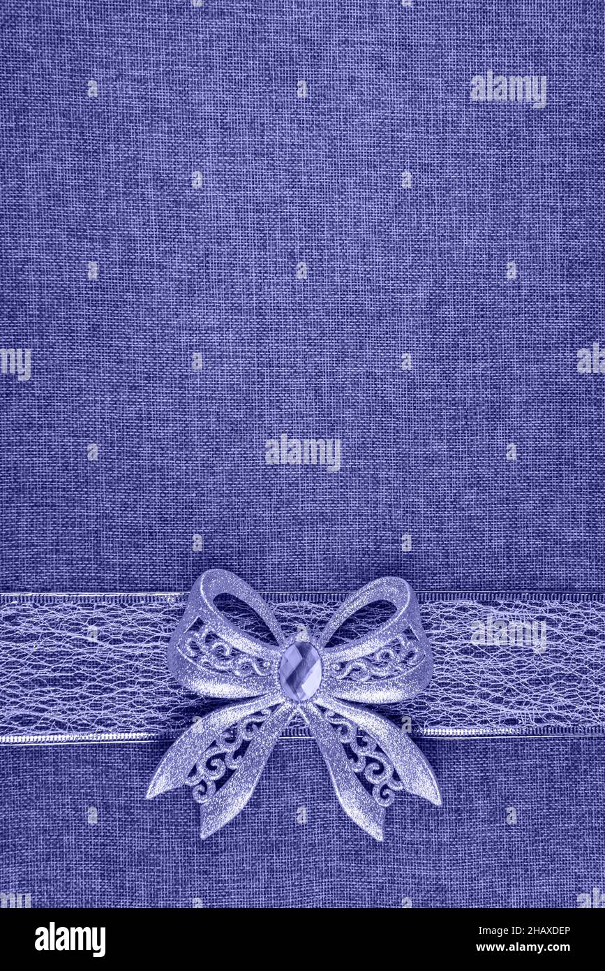 Elegant shiny tied glittering bow and ribbon on natural burlap textile ...