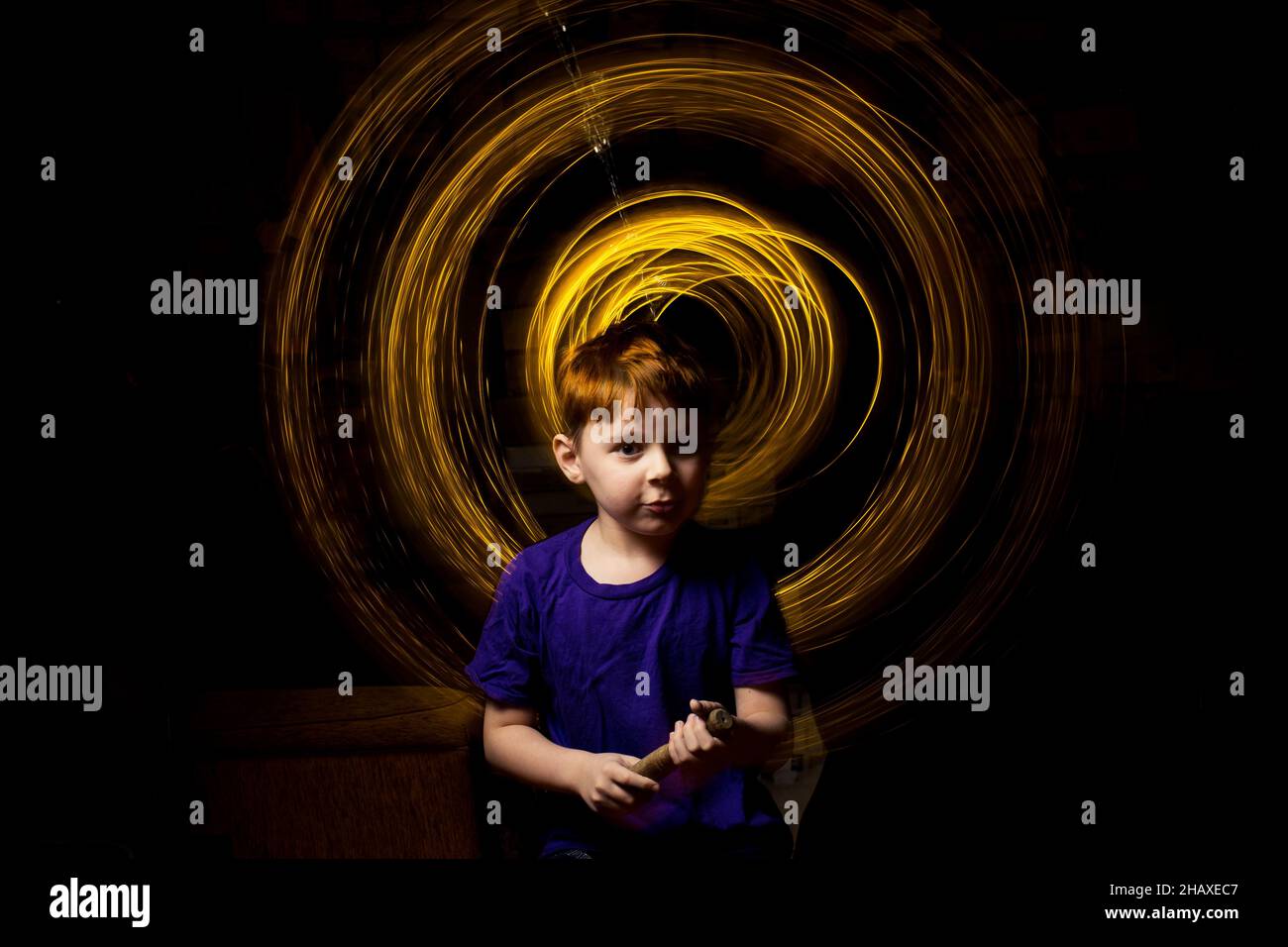 Young boy and round moving light from behind in the dark Stock Photo ...