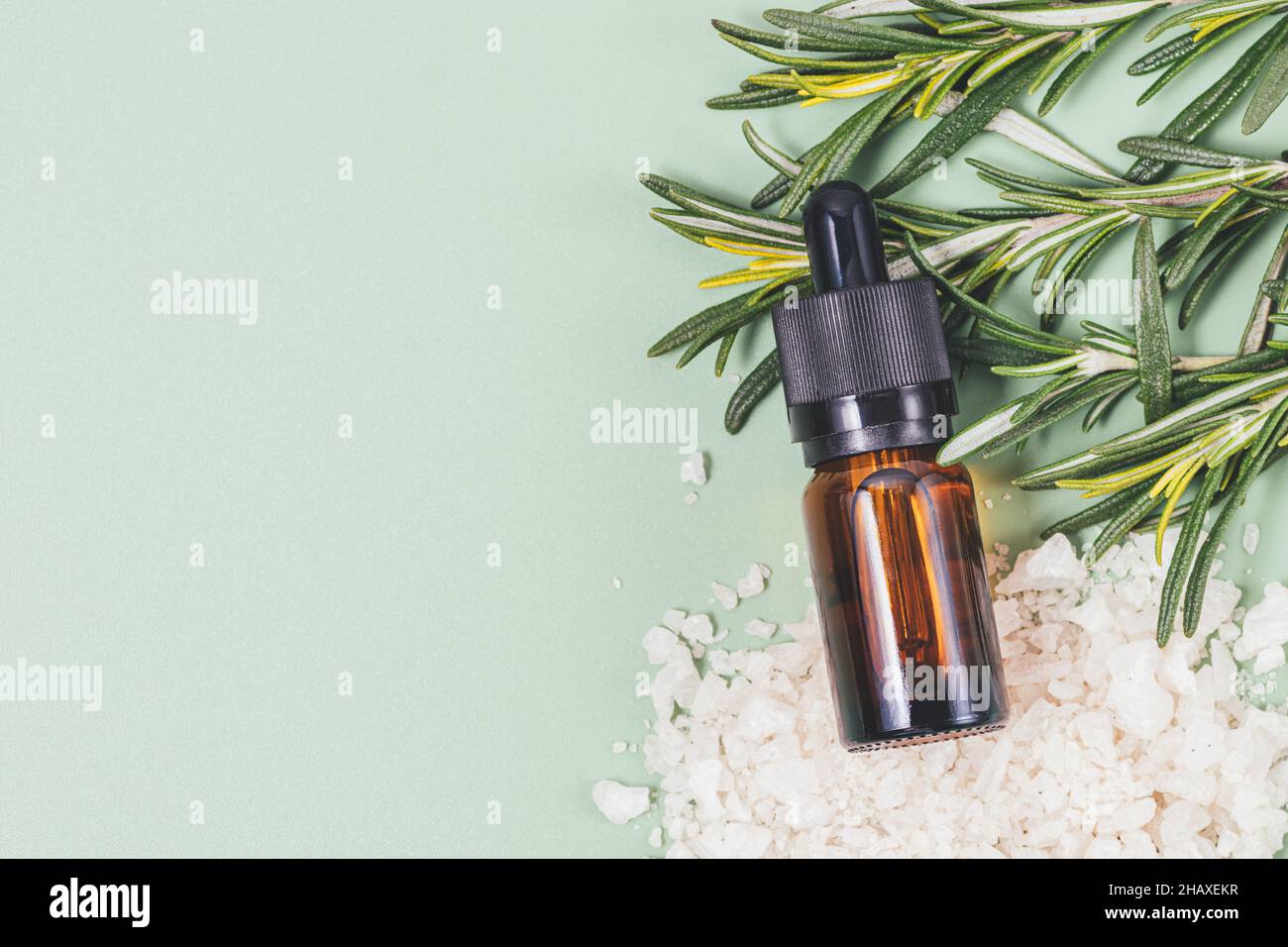 Rosemary essential oil bottle next to fresh branches of rosemary and ...