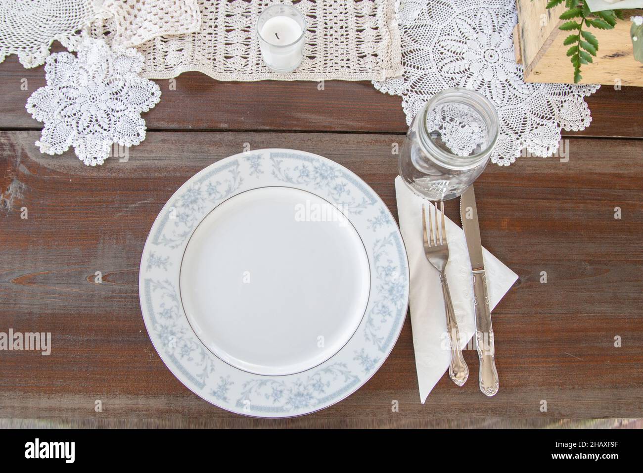 Vintage white plates at outdoor wood picnic table Stock Photo - Alamy