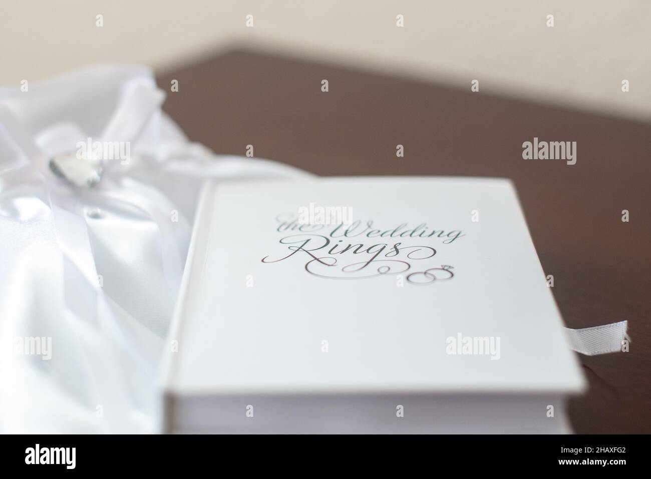 White ring box in the shape of a book with with text that reads "The ...