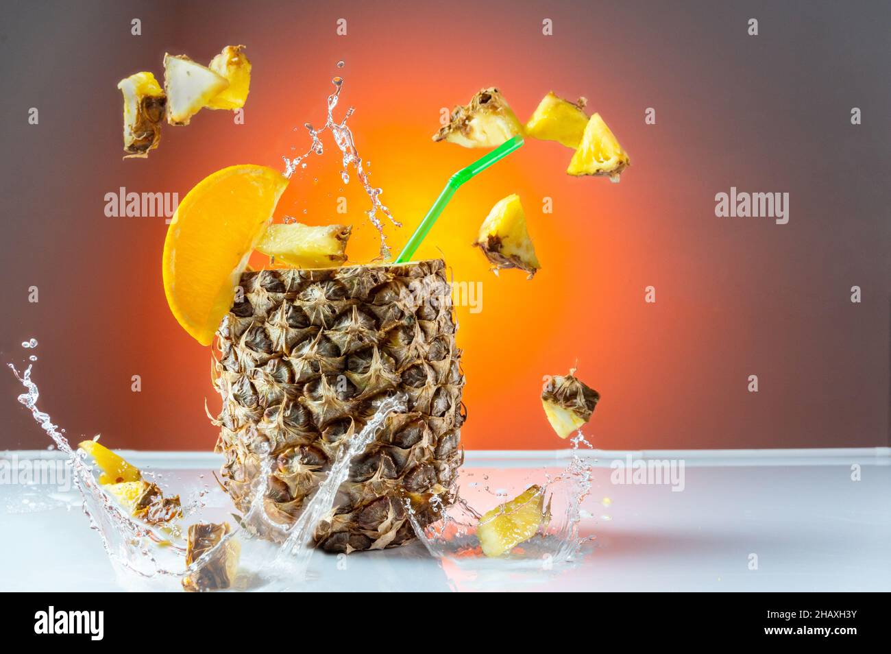 Pineapple cocktail. Pineapple with a straw. Flying pineapple slices and ...