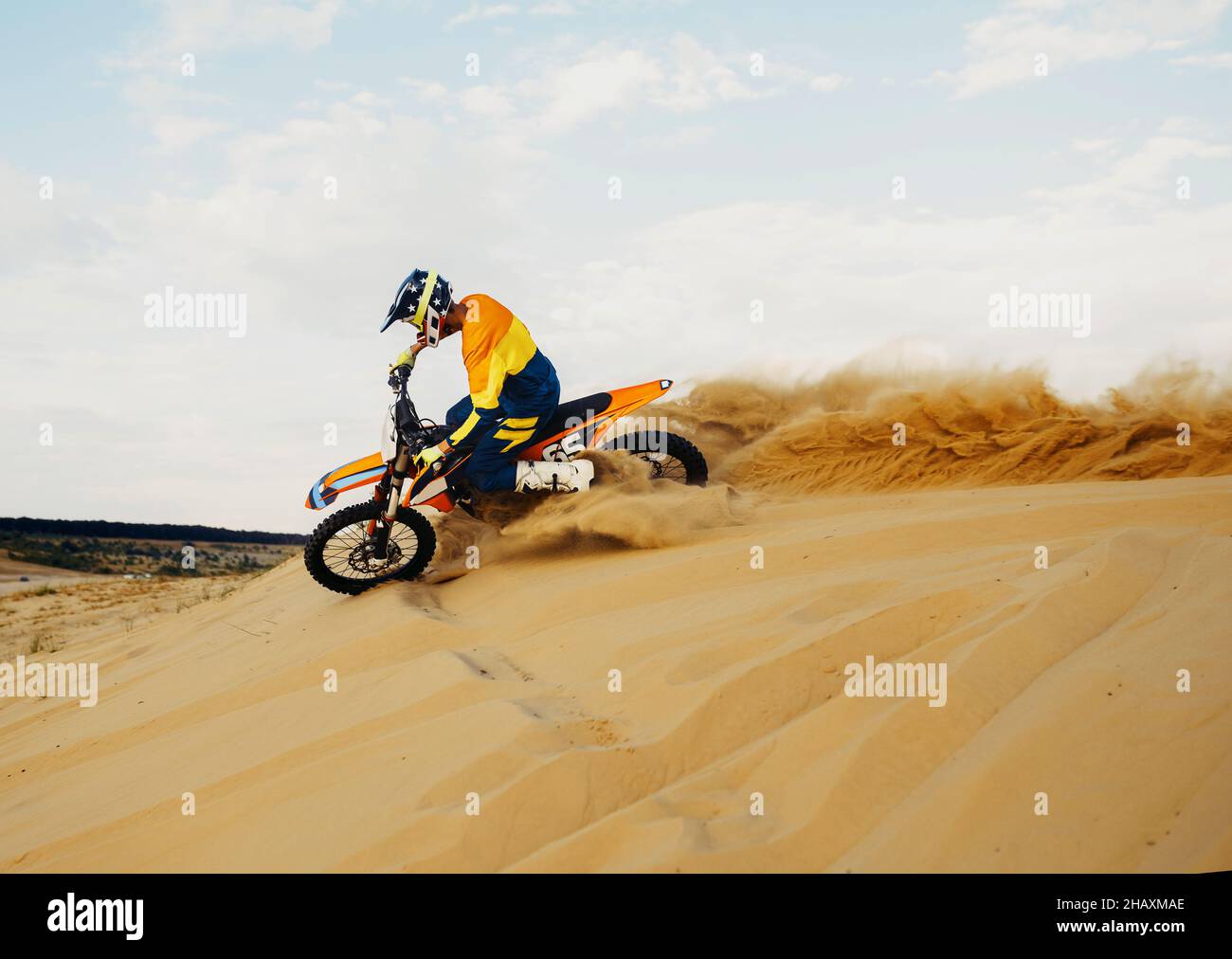 Professional motocross rider sliding down sand hill Stock Photo - Alamy
