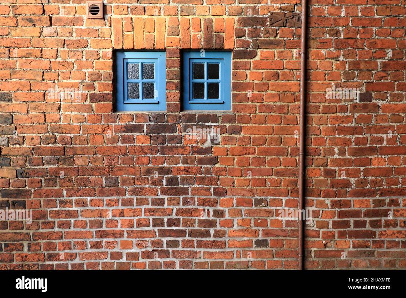 Brick building with small blue windows Stock Photo - Alamy