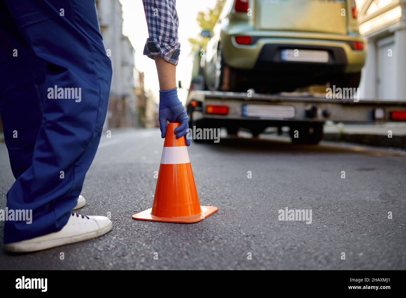 Road worker putting traffic cone on roadside Stock Photo - Alamy