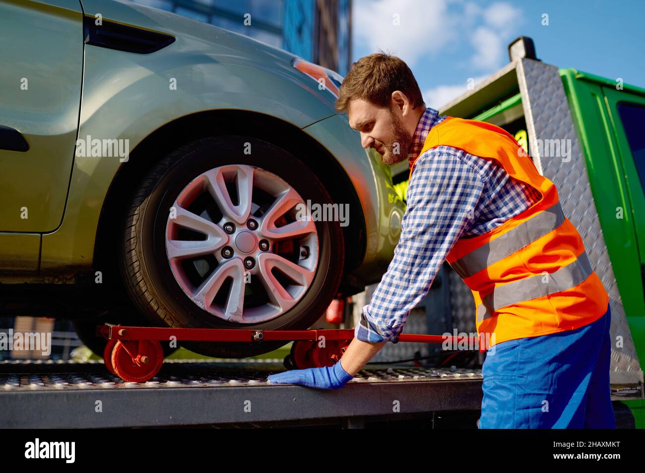 Tow truck operator fixing the car on platform Stock Photo - Alamy