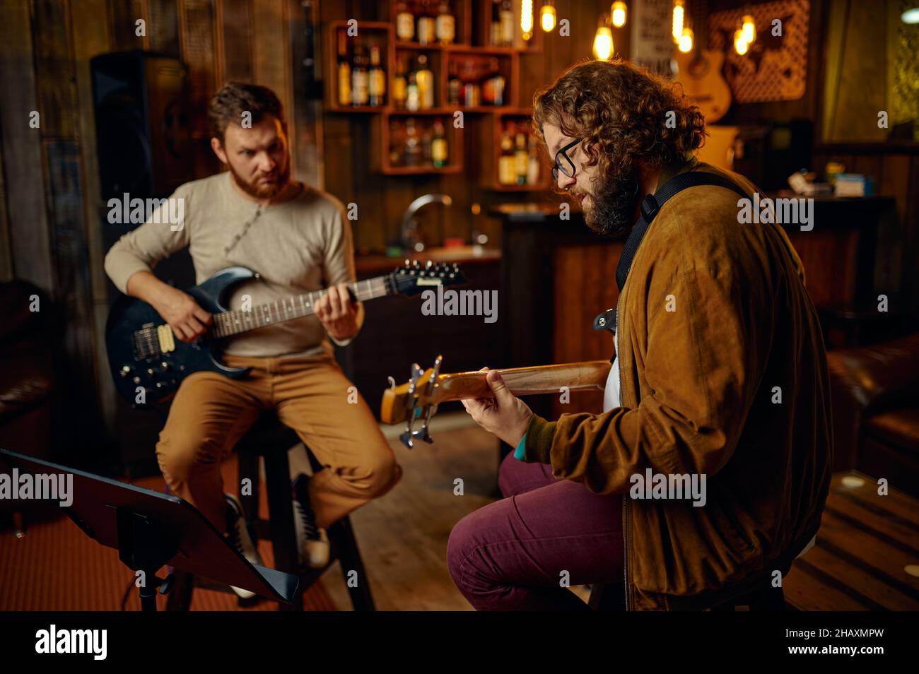 Teacher musician explaining how to play guitar Stock Photo - Alamy