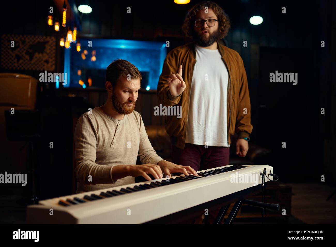 Tutor teaching young guy playing piano synthesizer Stock Photo - Alamy