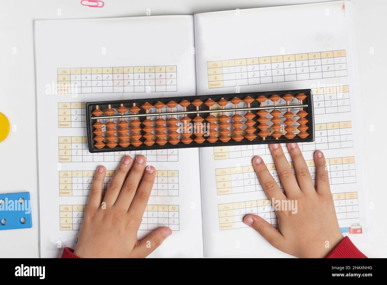 Doing mental math or mental arithmetic. Hand of little boy using abacus for calculating ...