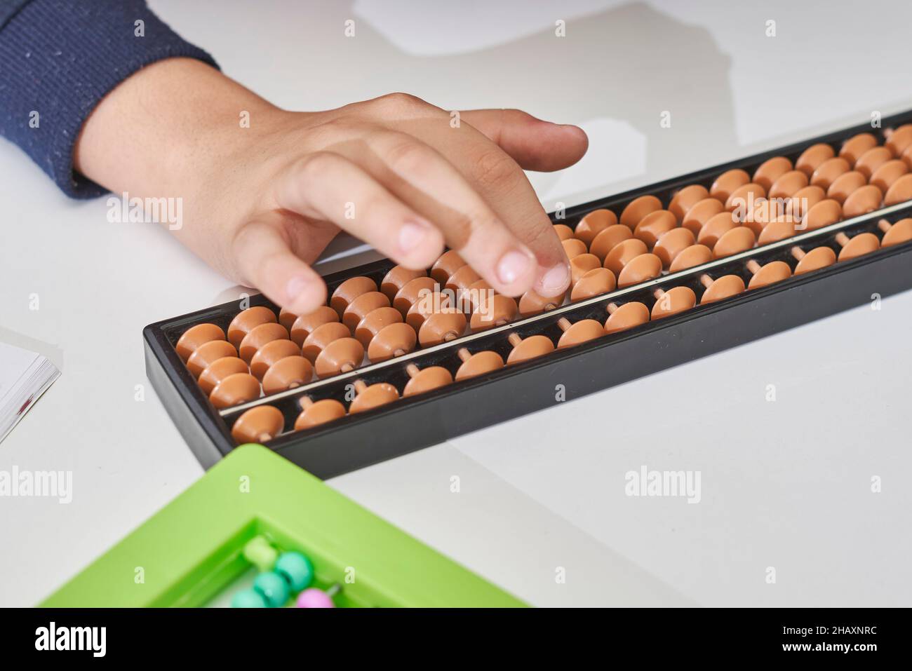 Doing mental math or mental arithmetic. Hand of little boy using abacus ...