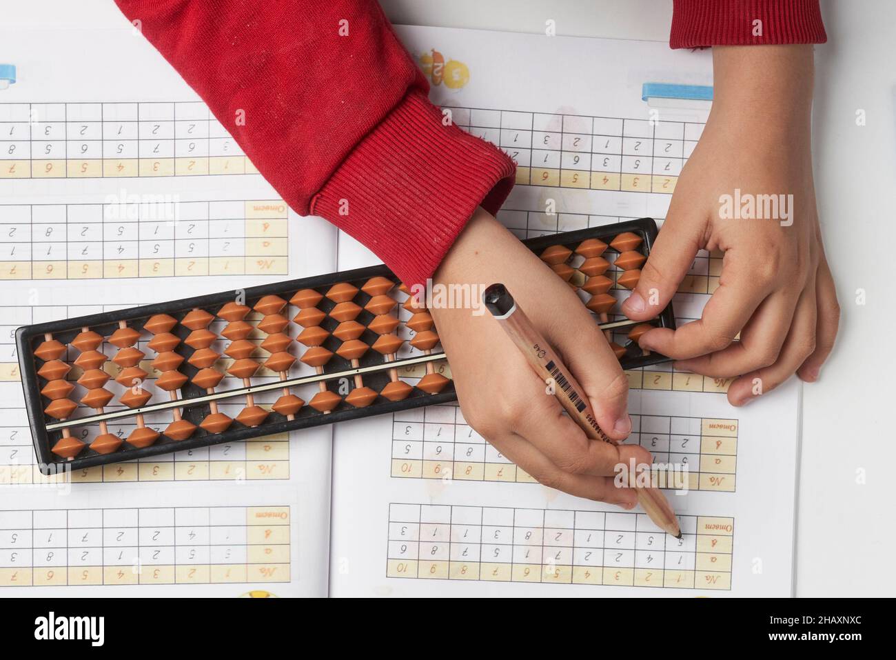 Doing mental math or mental arithmetic. Hand of little boy using abacus for calculating ...