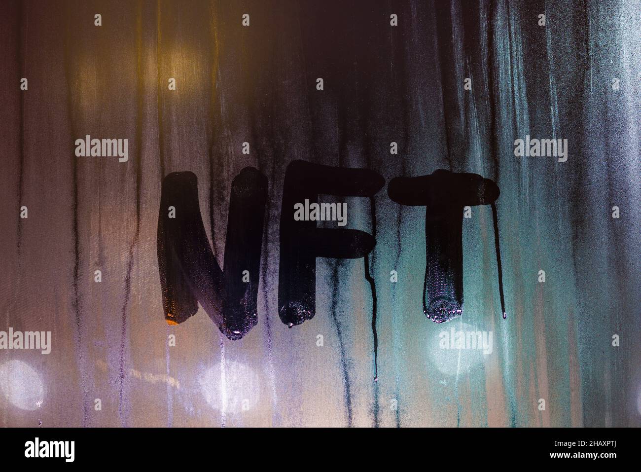 the word NFT - non-fungible token handwritten on foggy window glass at ...