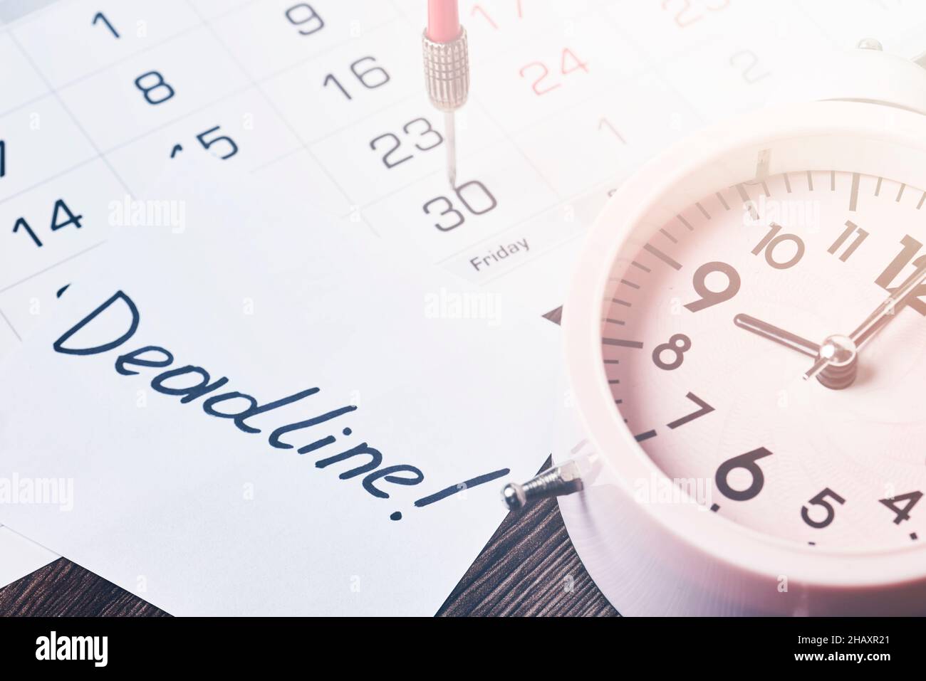 Deadline text on piece of paper, alarm clock and monthly calendar on ...