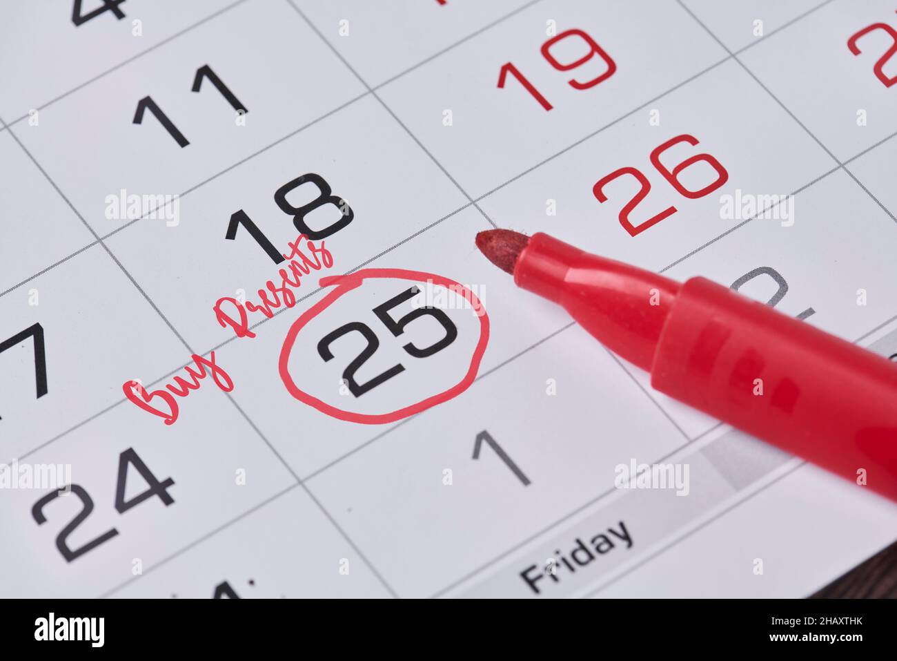 Planning Christmas costs. Writing reminder on December monthly calendar ...