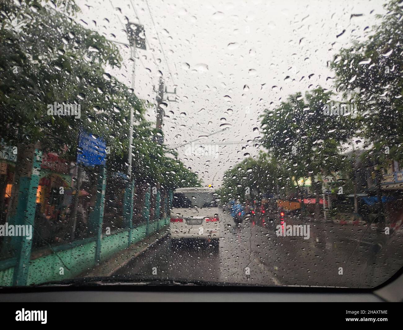 raindrops on the car window with a cloudy sky in the afternoon. taking ...